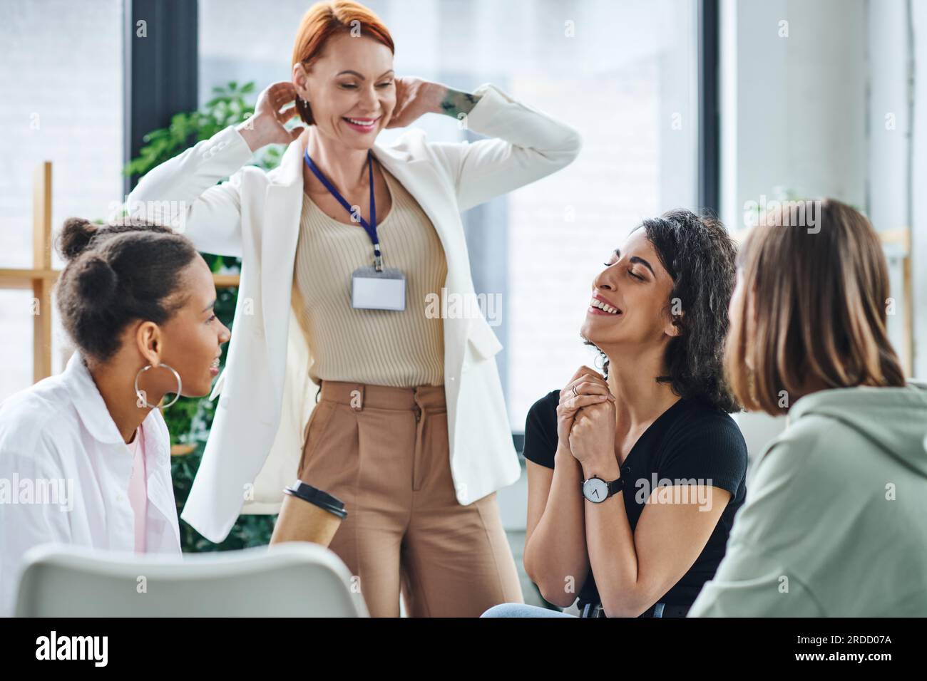 pleased motivation coach smiling near diverse multicultural group and ...