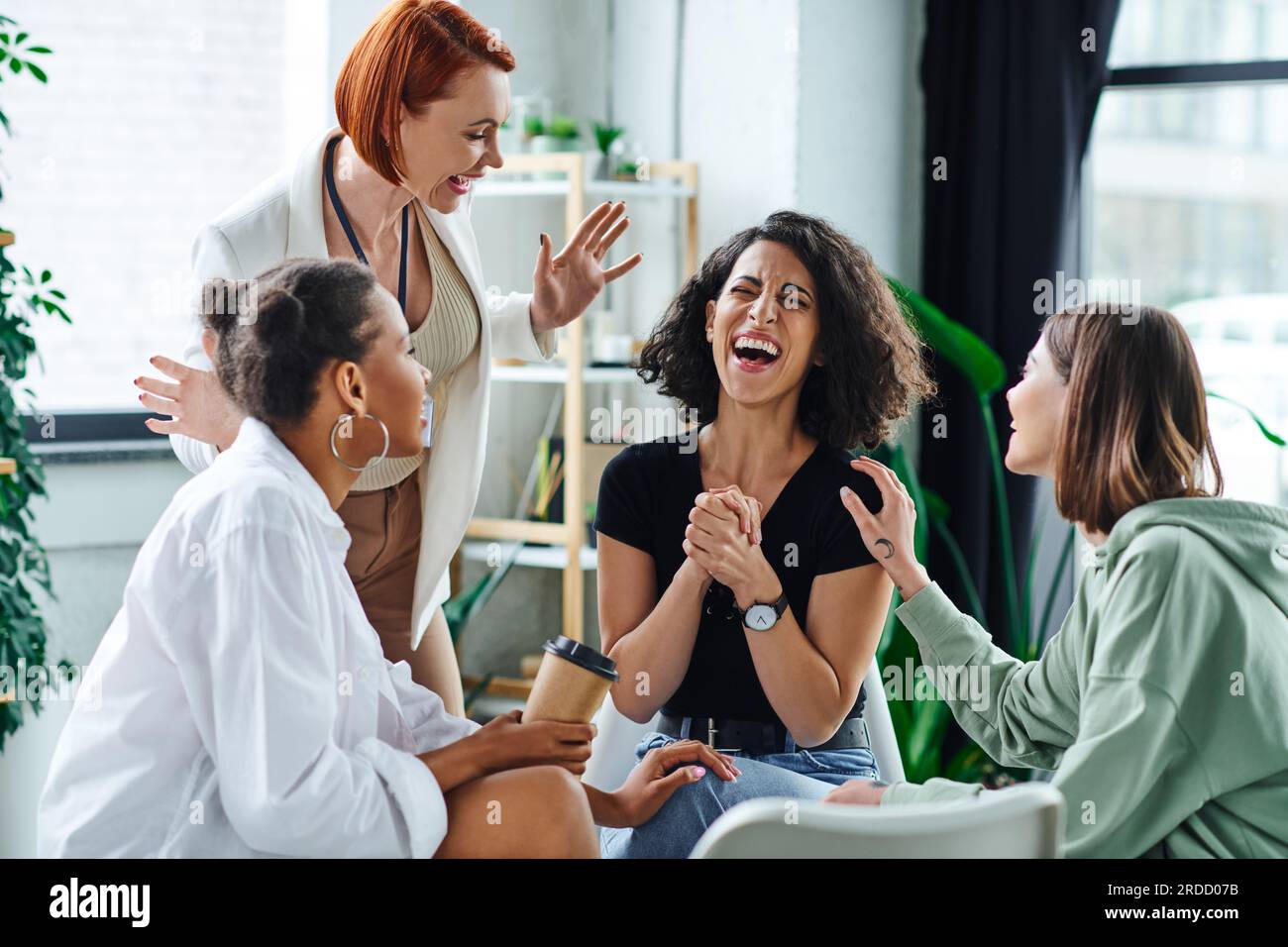 happy psychologist gesturing near excited multiracial woman laughing ...