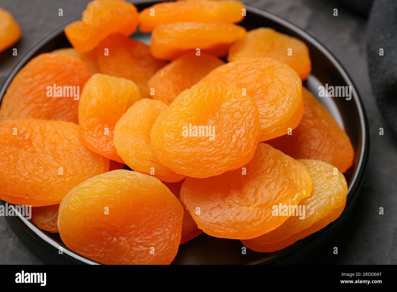 Tray with tasty dried apricots on black background Stock Photo - Alamy