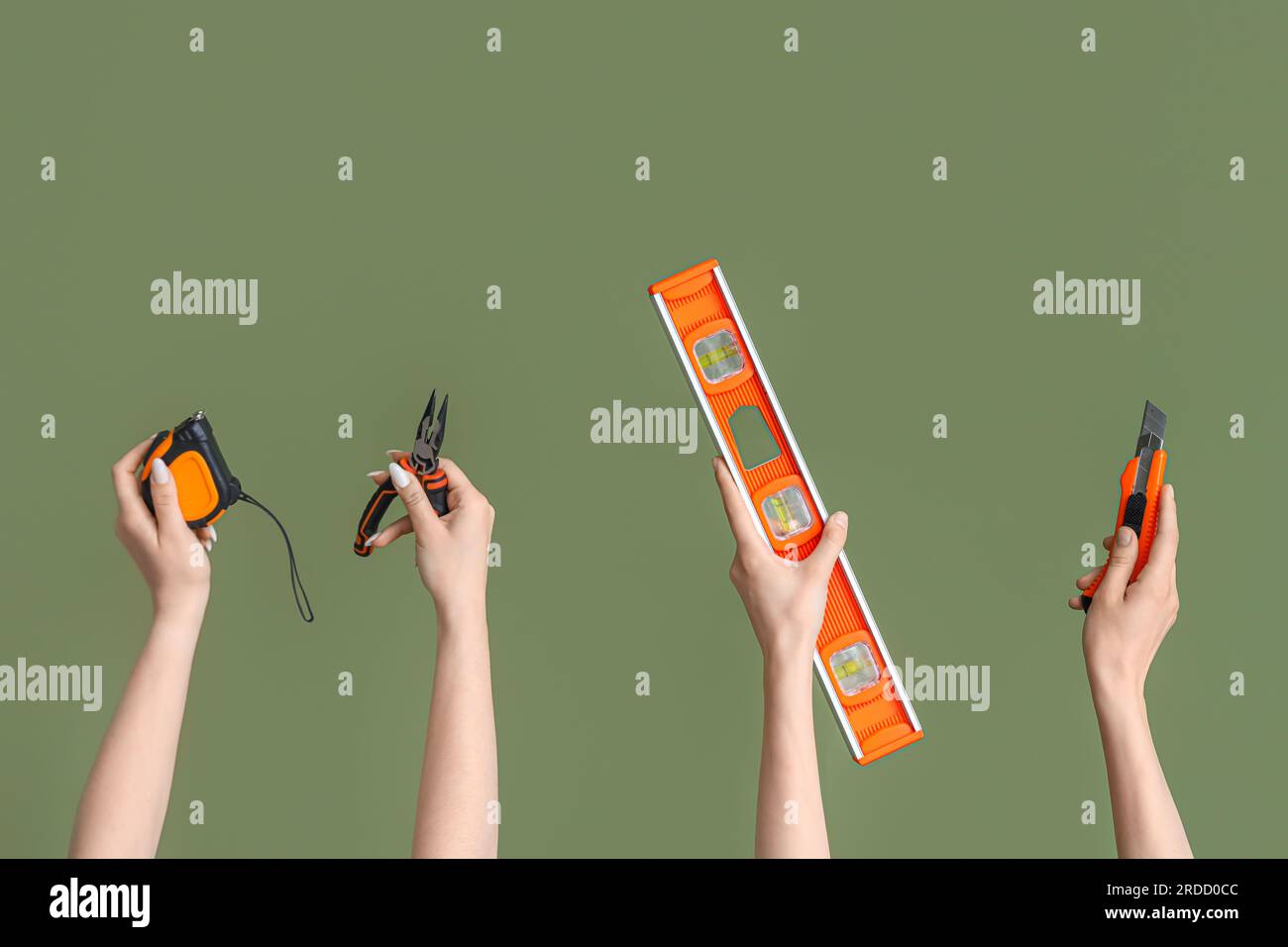 Electrician hands with tools on green background Stock Photo - Alamy