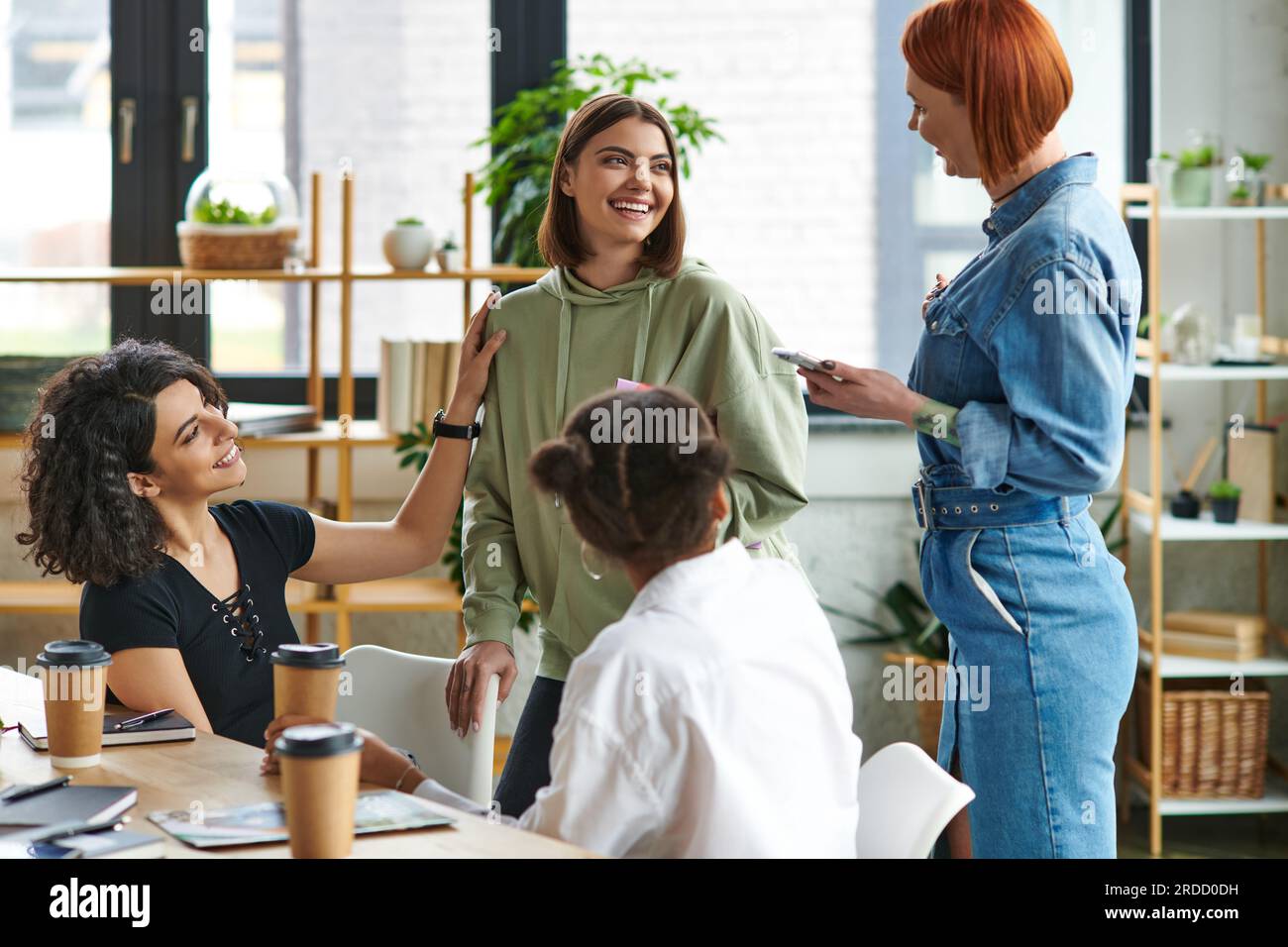 optimistic multicultural female friends talking to pleased young woman ...