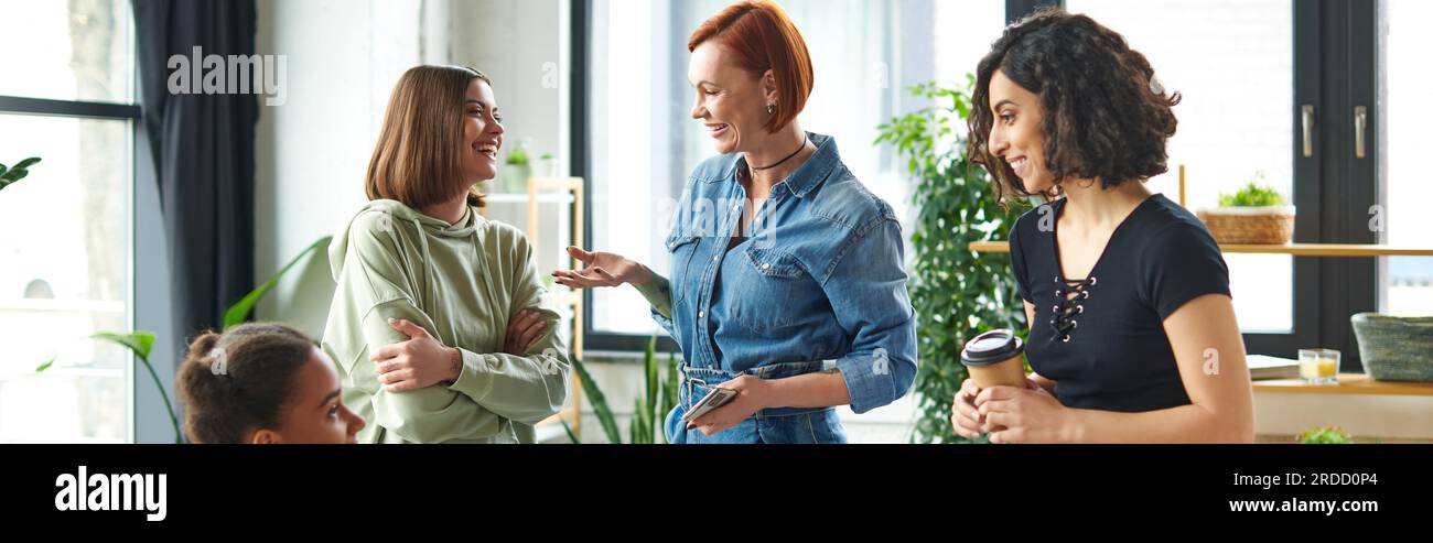 redhead woman with coffee to go pointing with hand while talking to ...