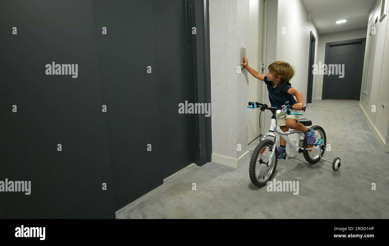Child pressing elevator button entering with bicycle Stock Photo - Alamy