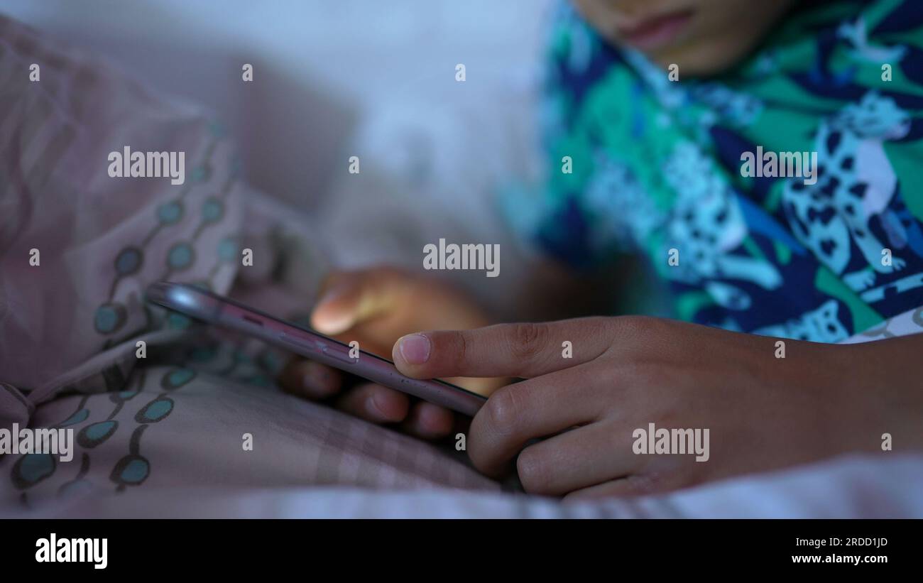 Child scrolling through phone screen in morning bed Stock Photo - Alamy