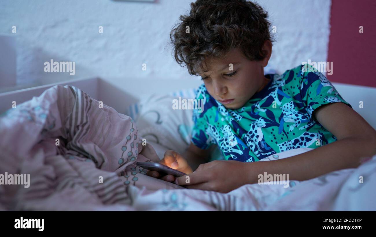 Child scrolling through phone screen in morning bed Stock Photo - Alamy