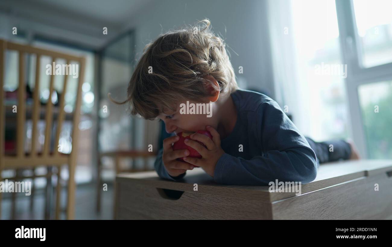 Child taking a bite of apple fruit kid eats healthy snack Stock Photo ...