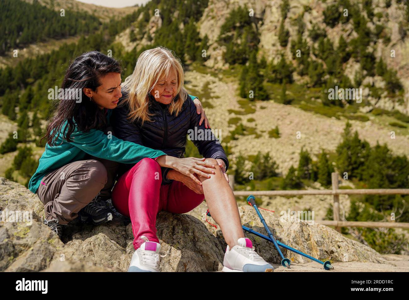 Two women help and care each other. Elderly woman got injured her knee ...