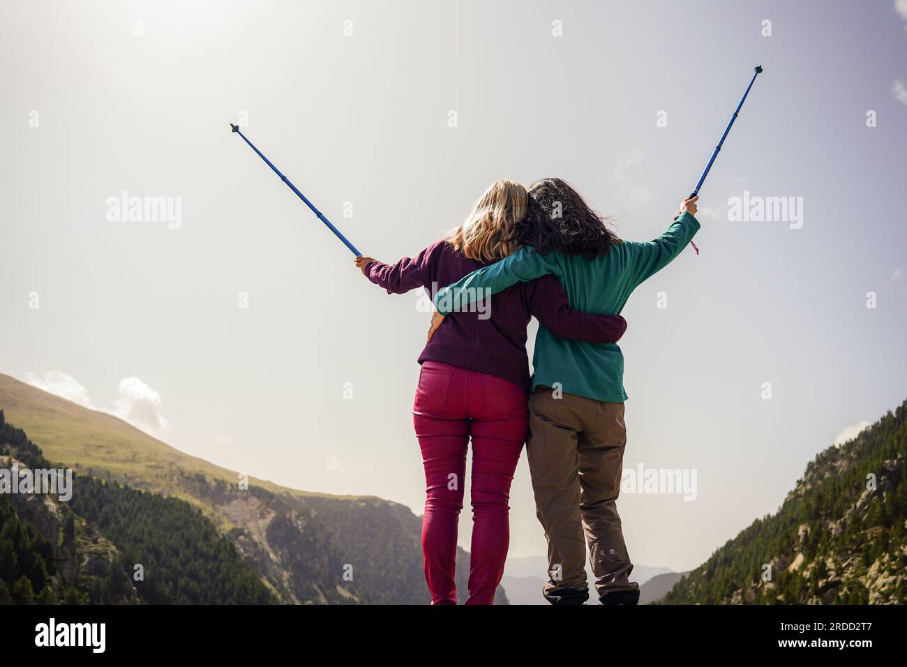 Mother and daughter enjoying the view at mountain landscape, standing ...