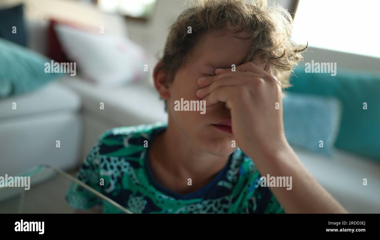 Tired Child rubbing face in frustration upset preoccupied kid Stock ...