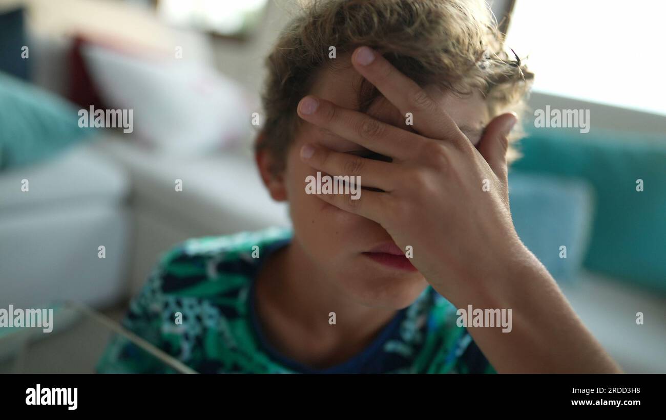 Tired Child rubbing face in frustration upset preoccupied kid Stock ...