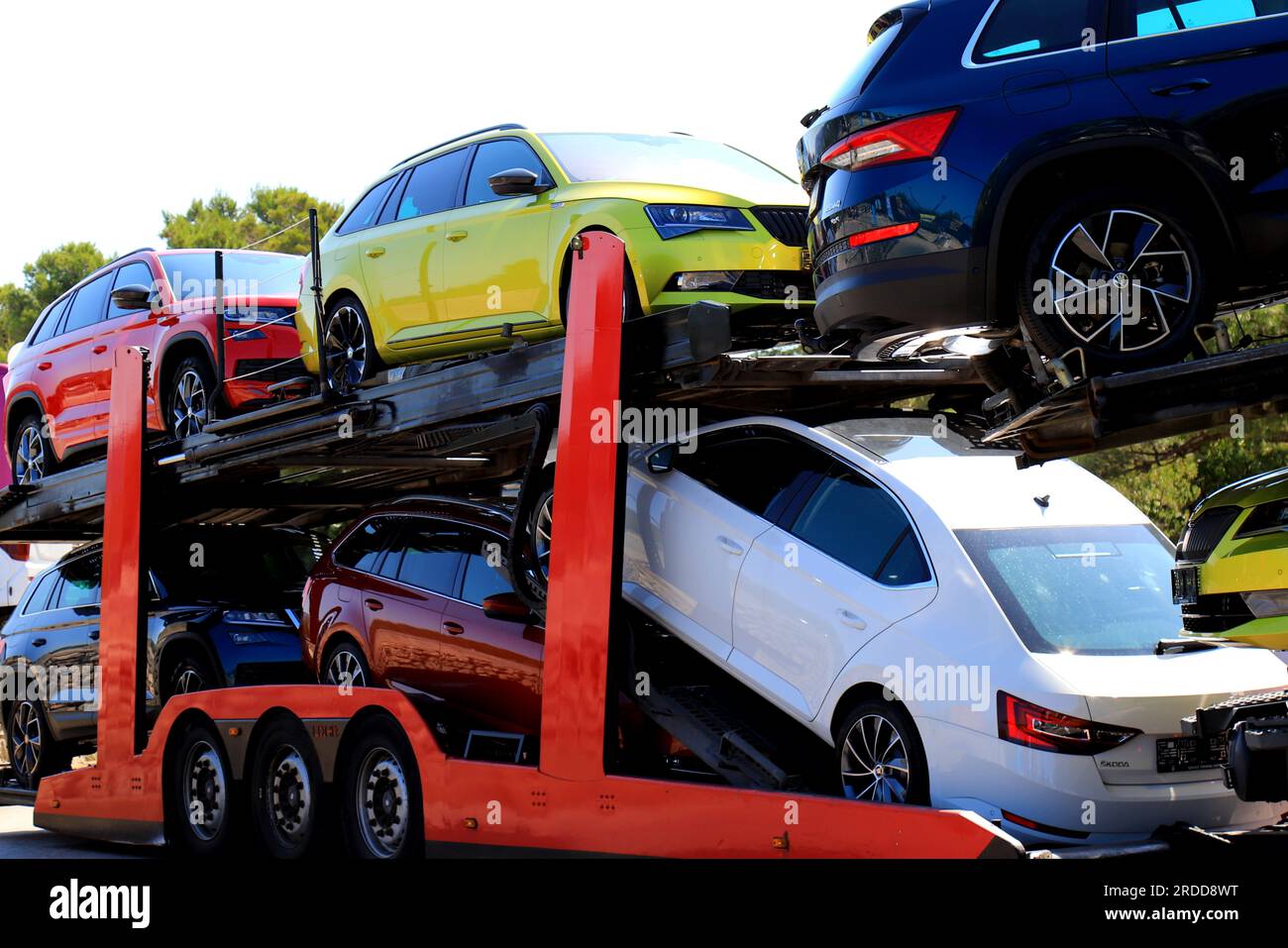 Auto transporter carries new cars of blue, yellow colors from factory ...
