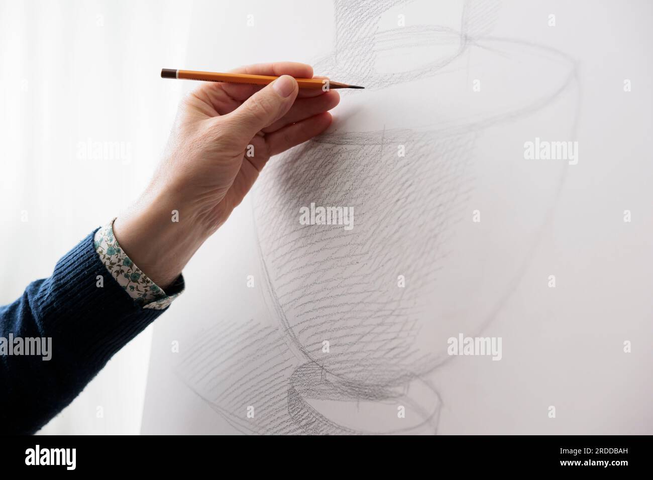 Close up of male hand holding pencil drawing on canvas, sketching vase ...