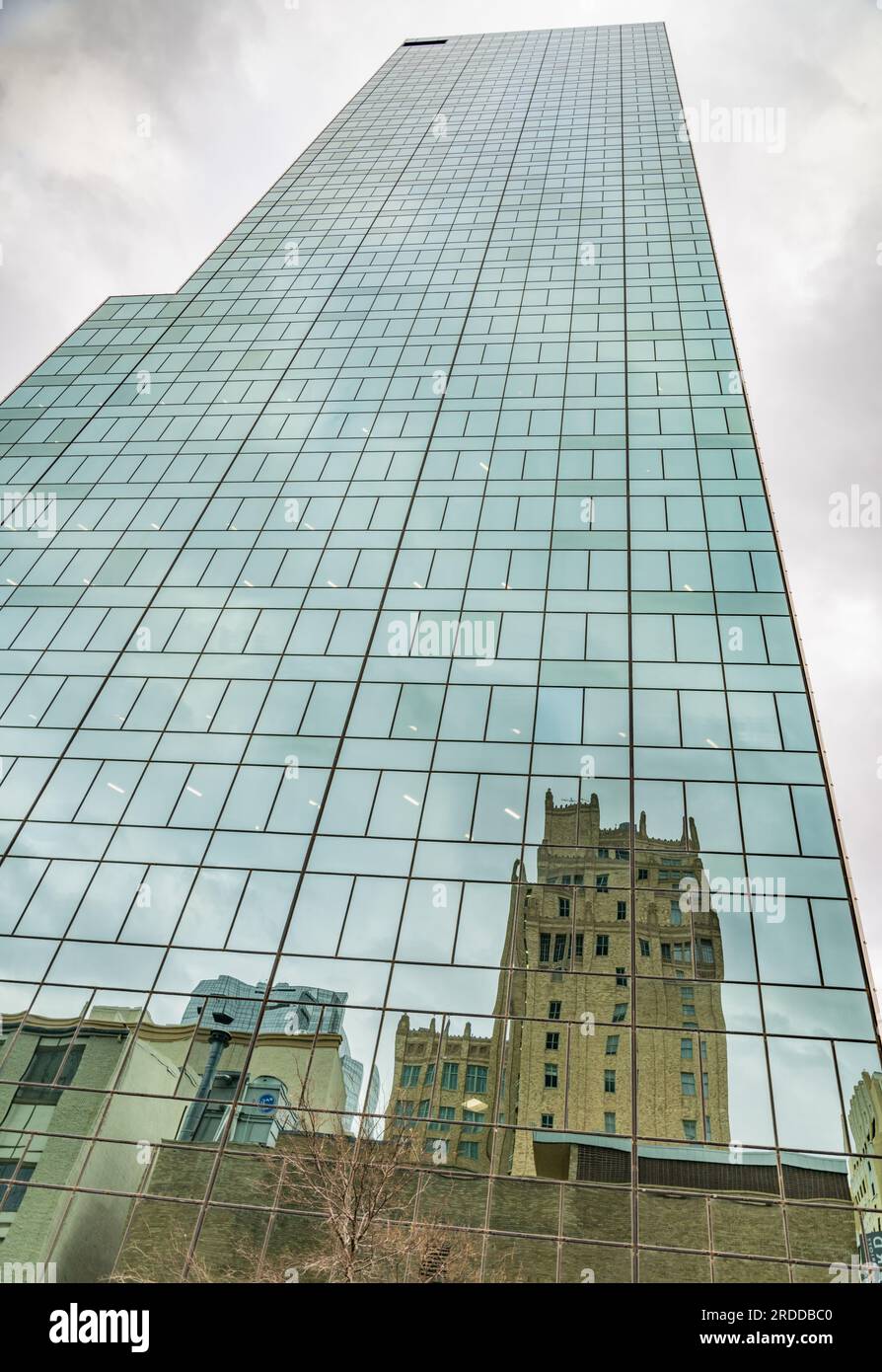 Reflection of older and new buildings in mirrored exterior of modern ...