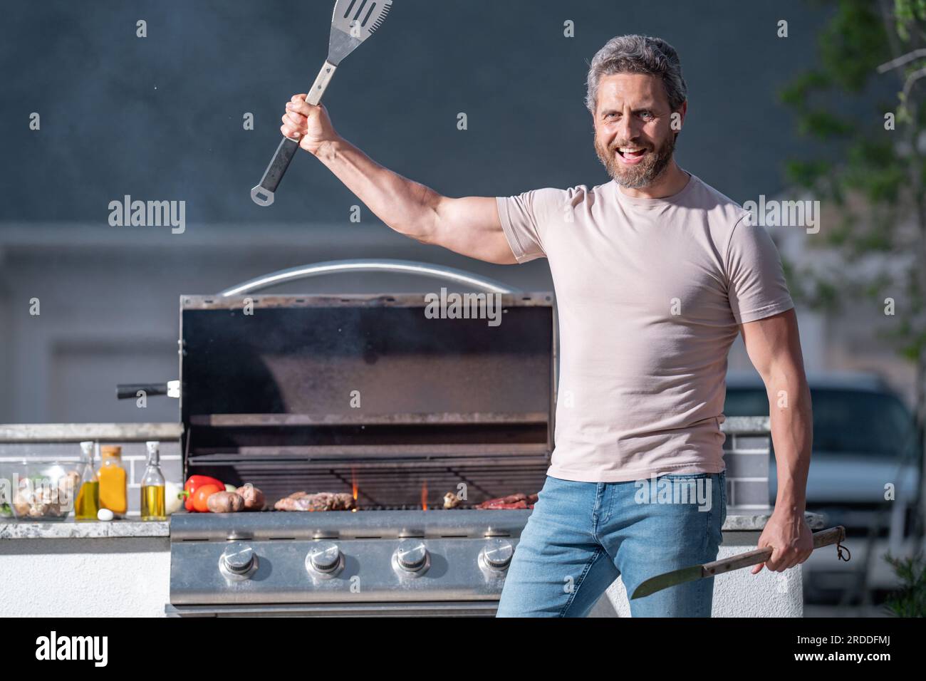 Male chef grilling and barbequing in garden. Barbecue outdoor garden ...