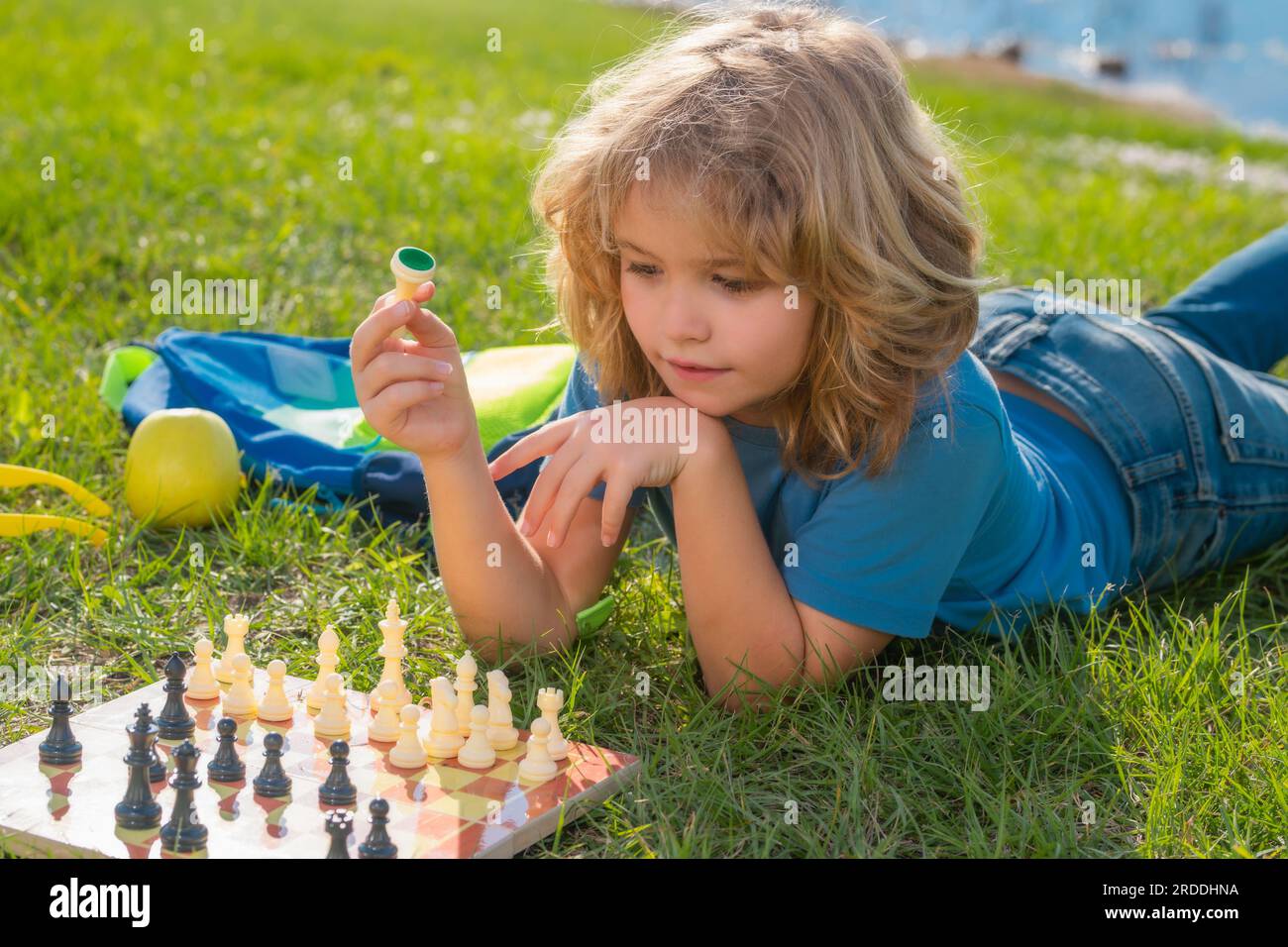 Child playing chess. Clever kid thinking about chess Stock Photo - Alamy