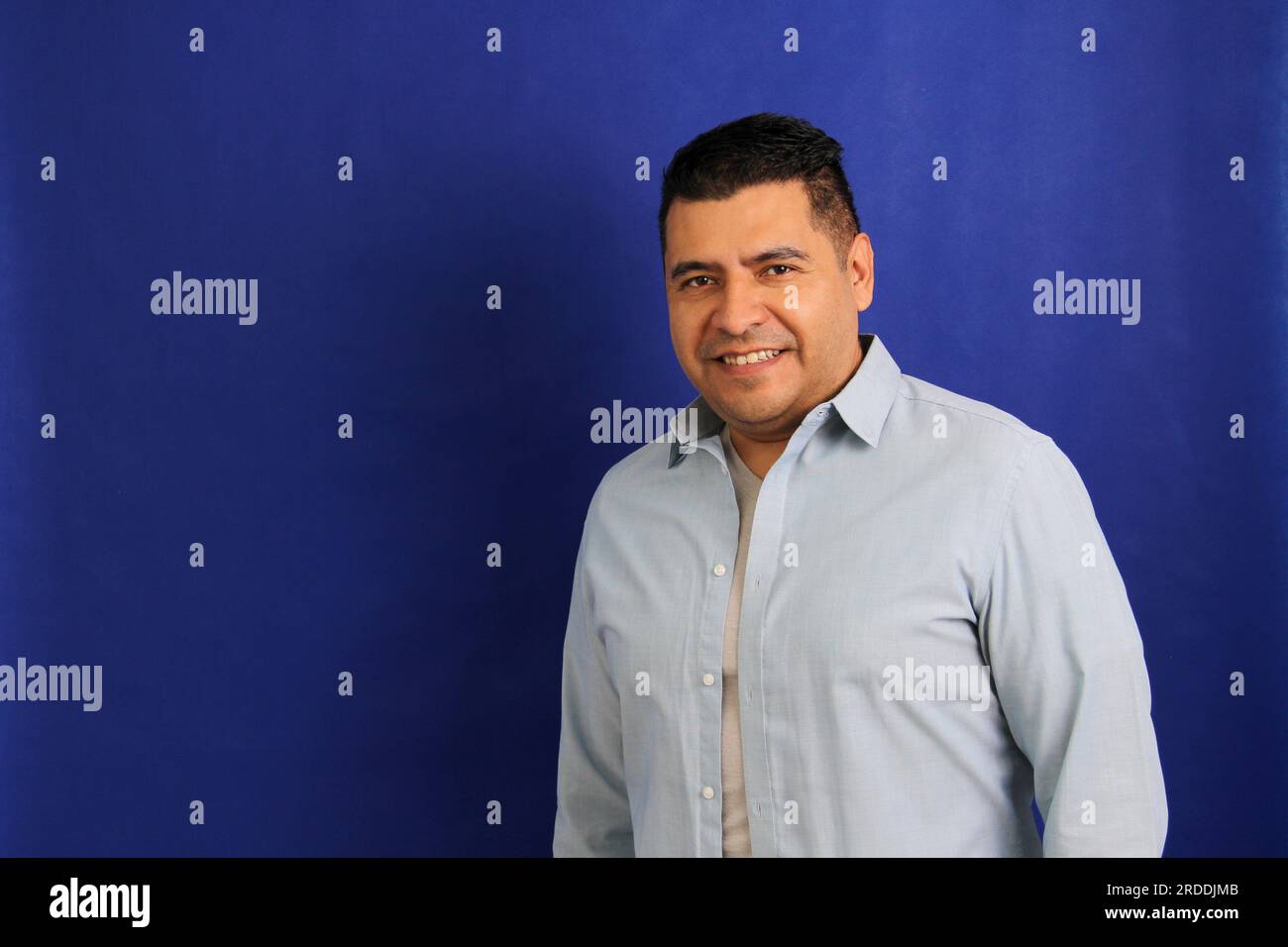 Happy and successful 40-year-old dark-haired Latino man smiles and ...