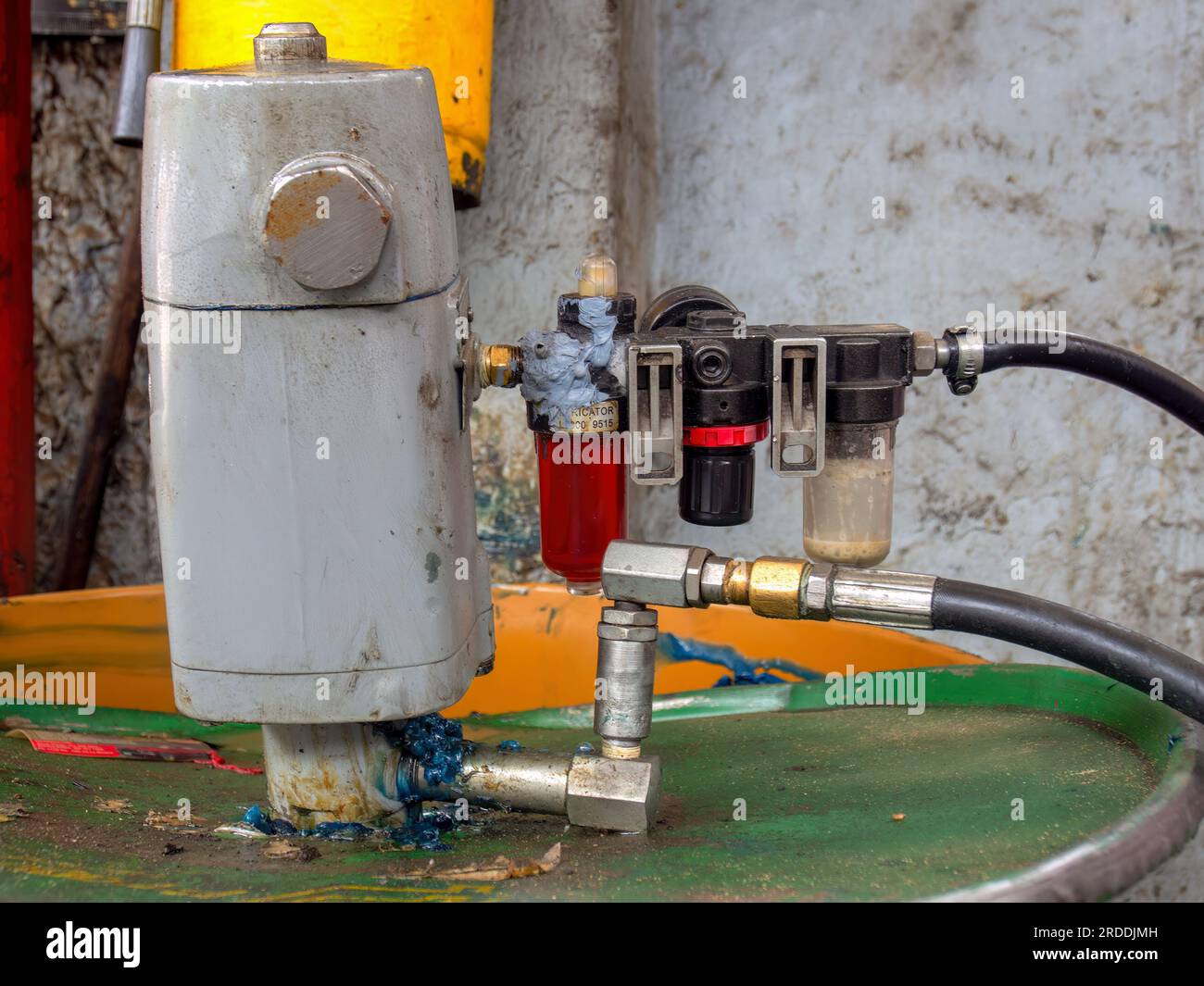 Close-up of a very rustic pneumatic grease system in a car workshop in ...