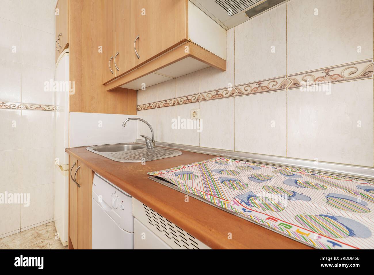corner of a small kitchen with a cherry wood color countertop to match ...