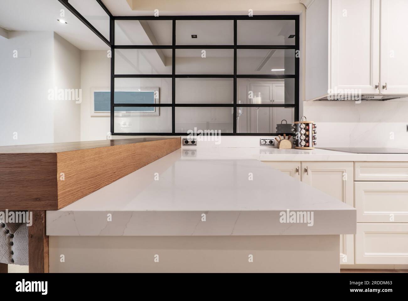 kitchen furnished with white wood cabinets, white stone counter ...