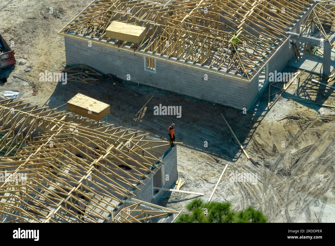 Builders working on roof construction of unfinished residential house ...