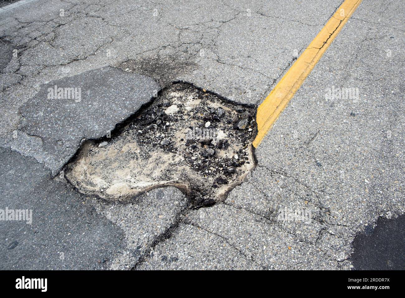 Damaged american road surface with deep pothole. Ruined street in ...