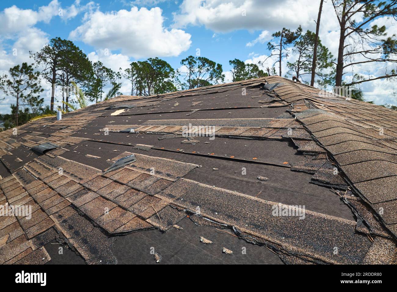 Damaged house roof with missing shingles after hurricane Ian in Florida ...