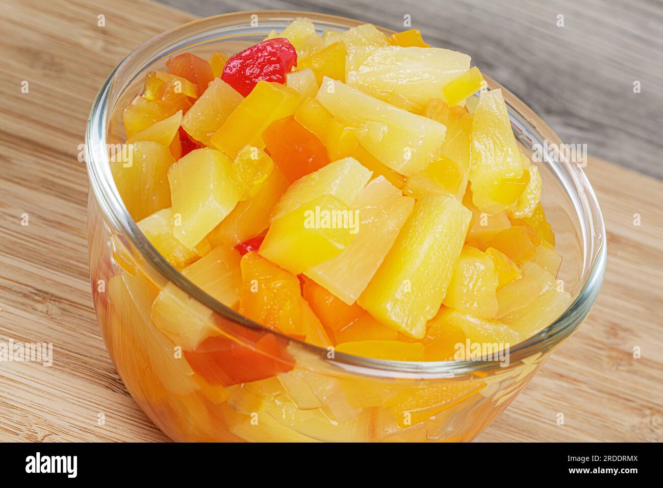A delicious glass bowl of Fruit Cocktail mix isolated on a wooden ...