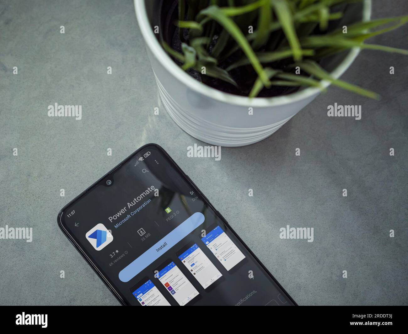 Lod, Israel - July 16,2023: Modern workspace with smartphone with Power Automate app play store ...