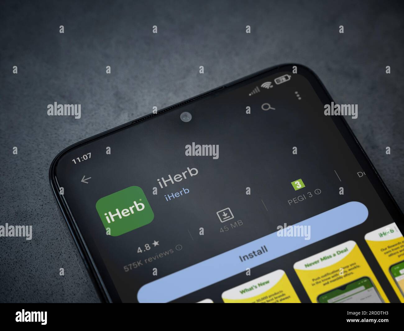 Lod, Israel - July 16,2023: iHerb app play store page on smartphone on a dark marble stone ...