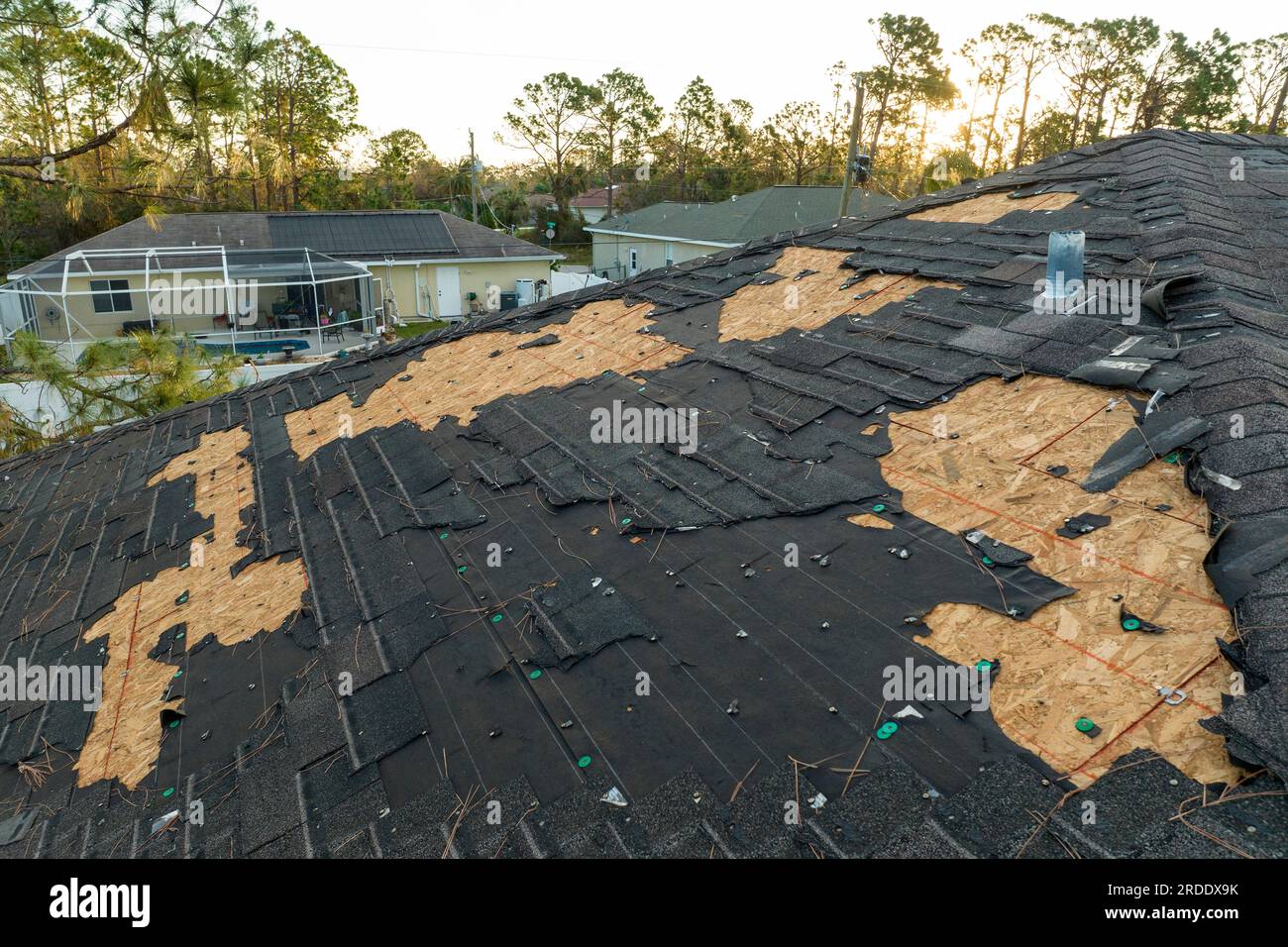 Ruined rooftop in need of repair. Wind damaged house roof with missing ...