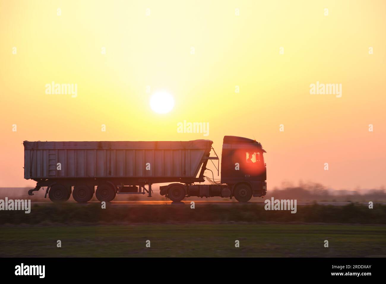 Semi-truck with tipping cargo trailer transporting sand from quarry ...
