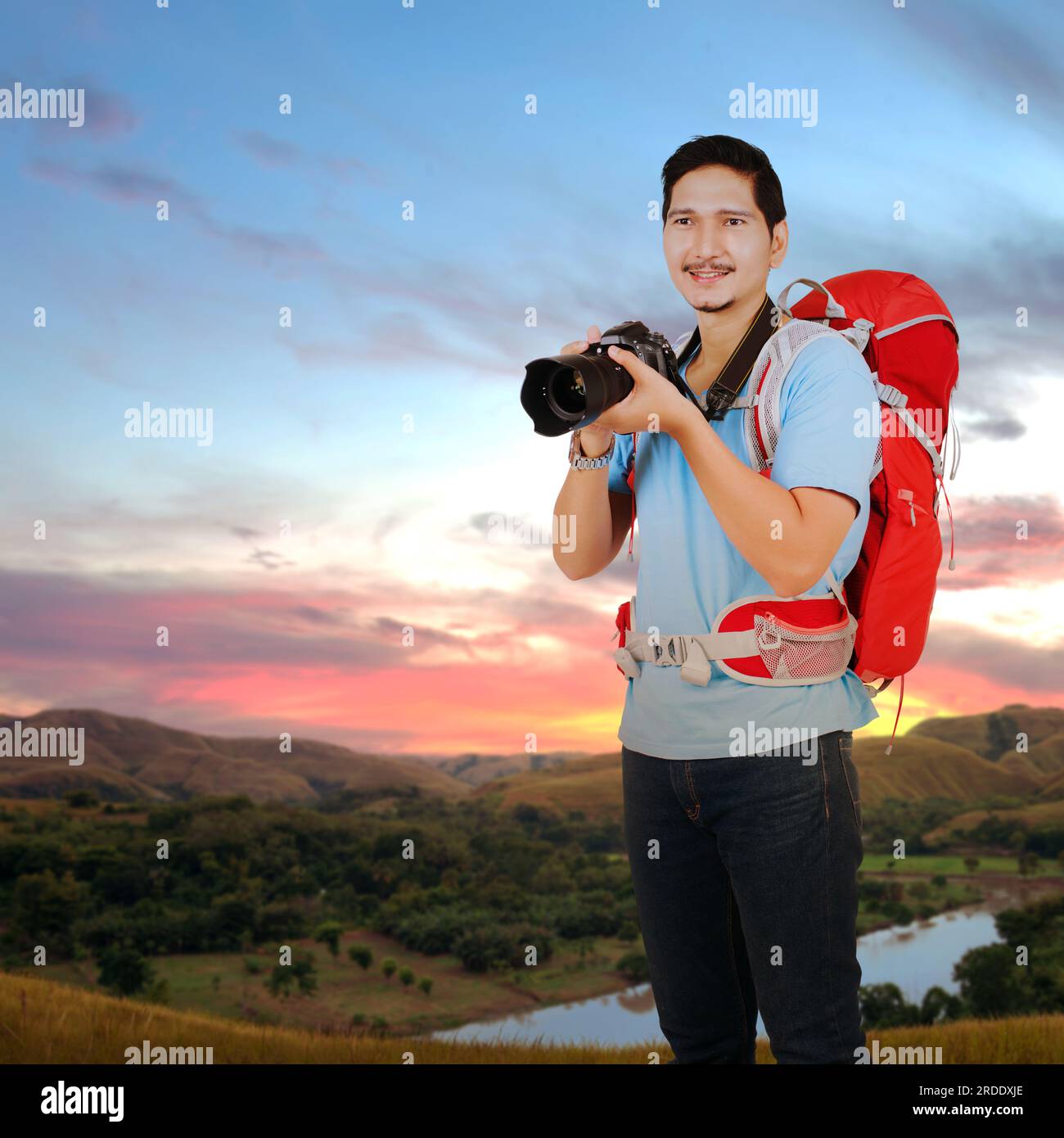 Asian man with a backpack holding the camera. World Photography Day ...