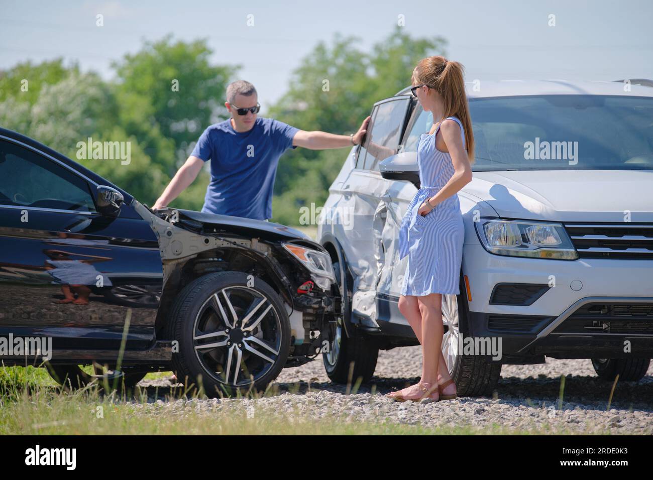 Angry woman and man drivers of heavily damaged vehicles arguing who is ...