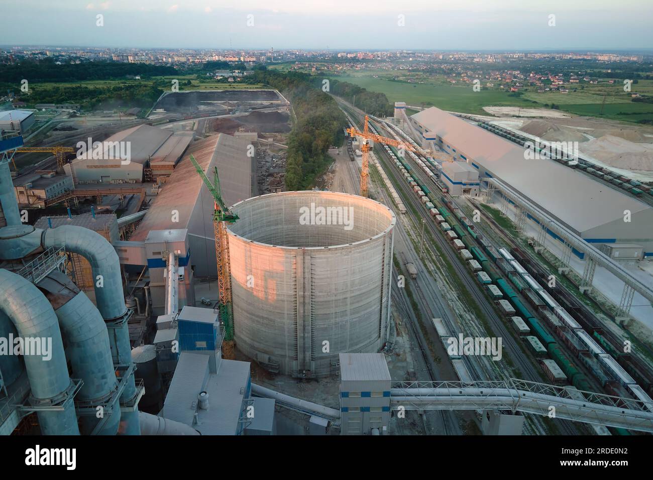 Cement plant with high factory structure and tower cranes at industrial ...