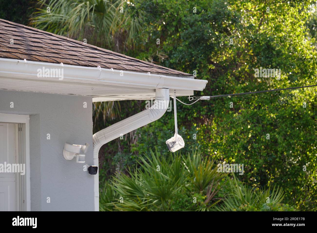 Motion sensor with light detector mounted on exterior wall of private ...