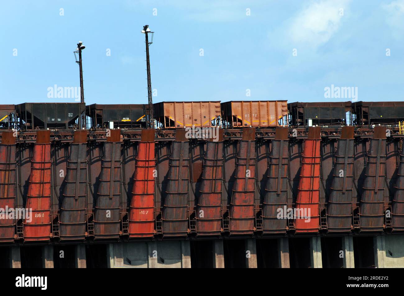 Conveyor has coal ore cars lined up for shipping. Train cars form line ...