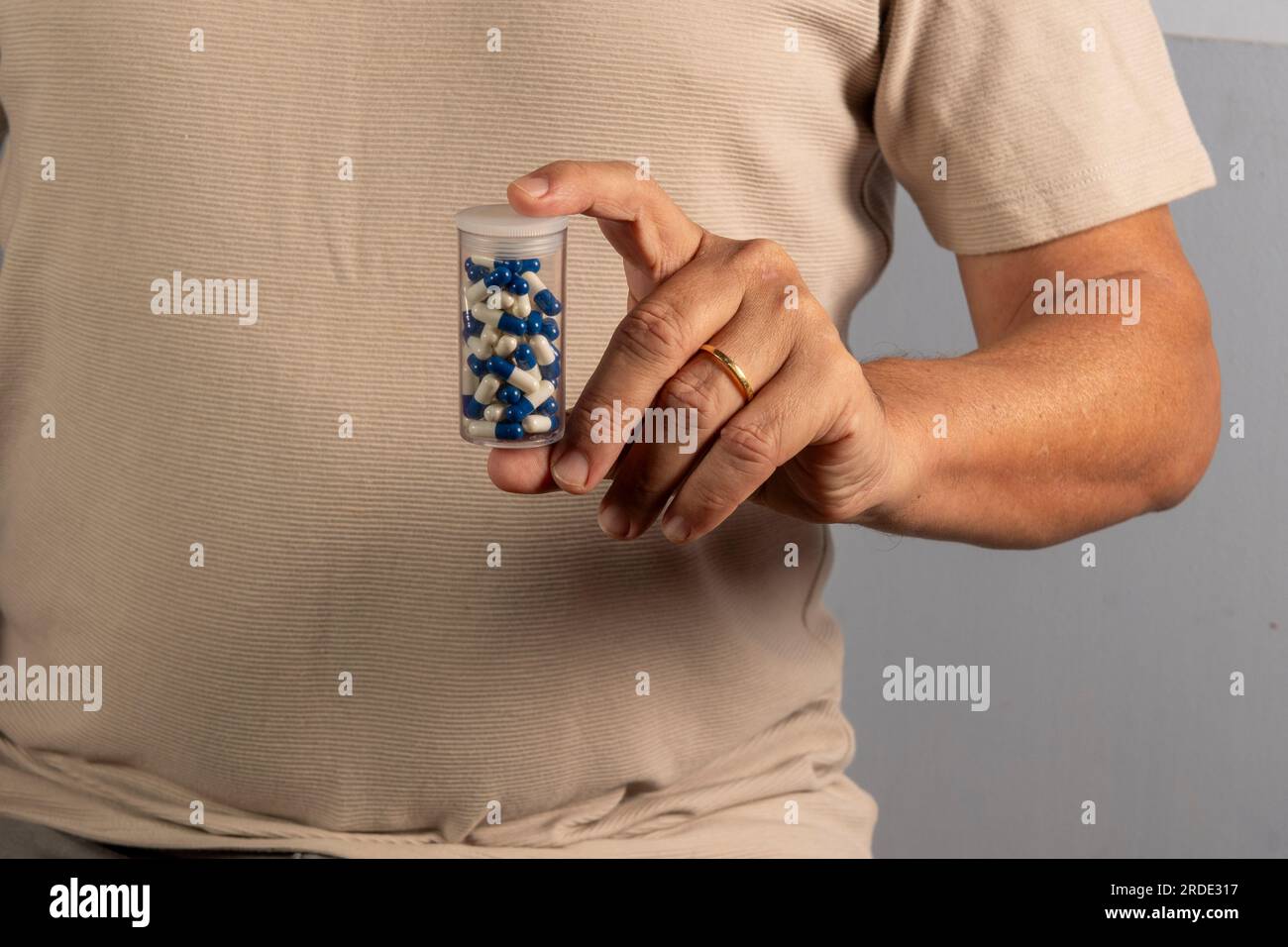 Hand holding bottle of pills representing different diseases. At home ...