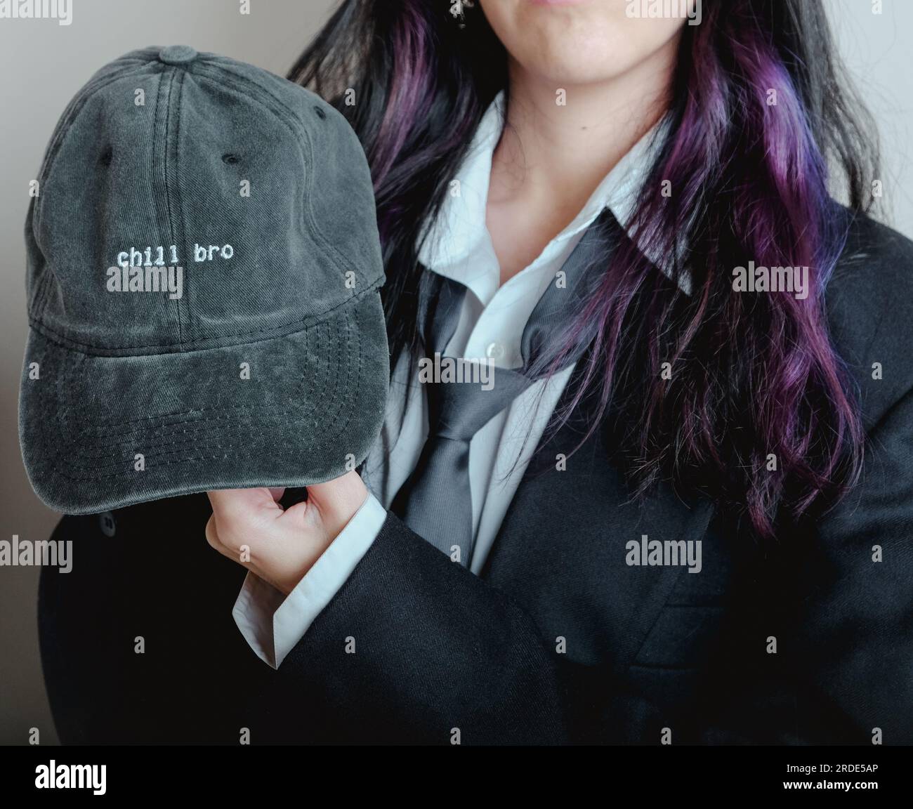 Young Woman Holding Gray Cap With ‘Chill bro’ Words On It Cap. Woman ...