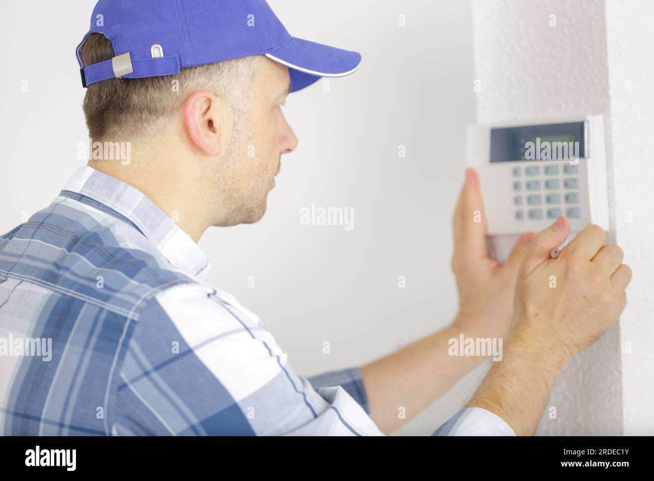 man installing security system on wall Stock Photo - Alamy