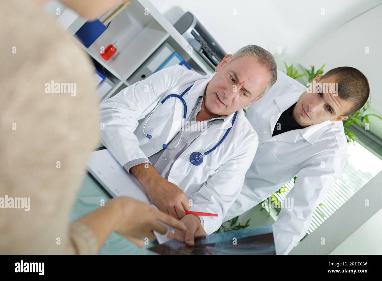doctor discussing xray results with patient junior doctor watching ...