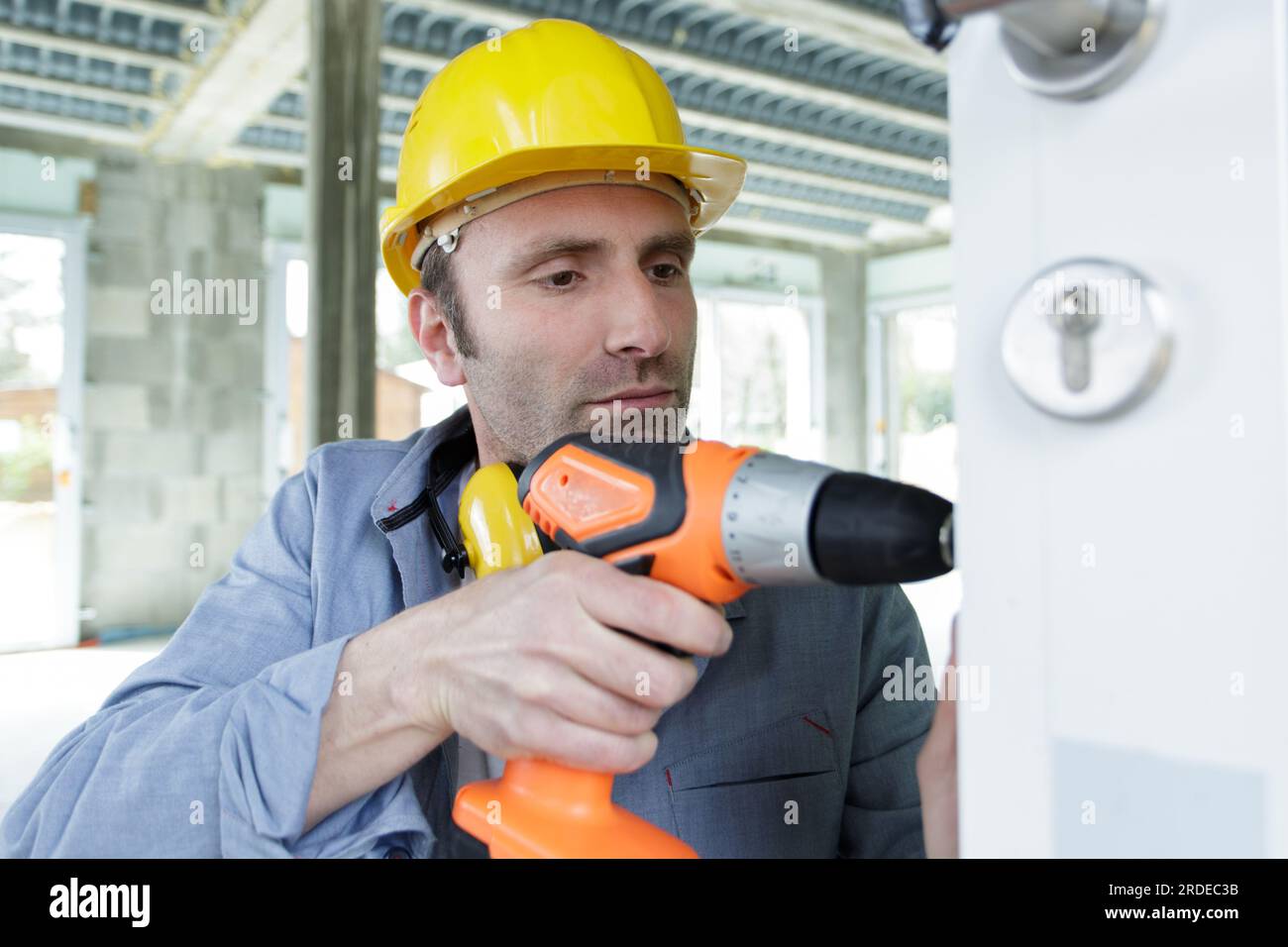 workman using cordless screwdriver on door lock Stock Photo - Alamy