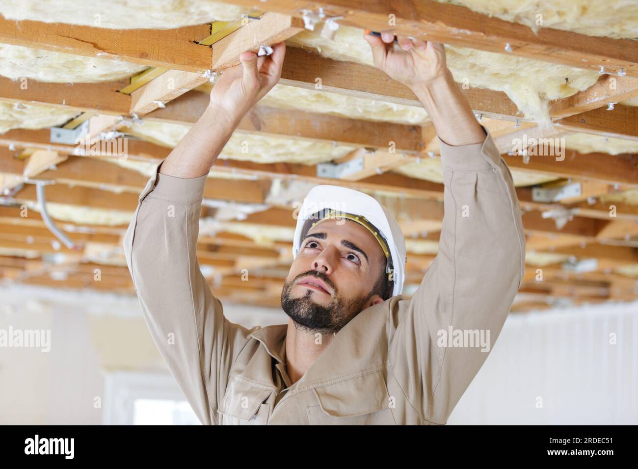 a construction worker fixing ceiling Stock Photo - Alamy