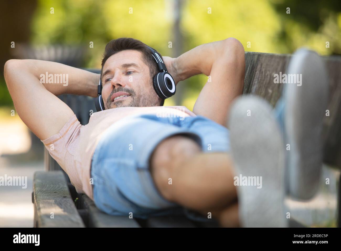 happy man is relaxing on a bench Stock Photo - Alamy