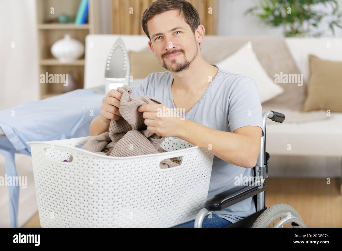 disabled man in wheelchair doing laundry Stock Photo - Alamy