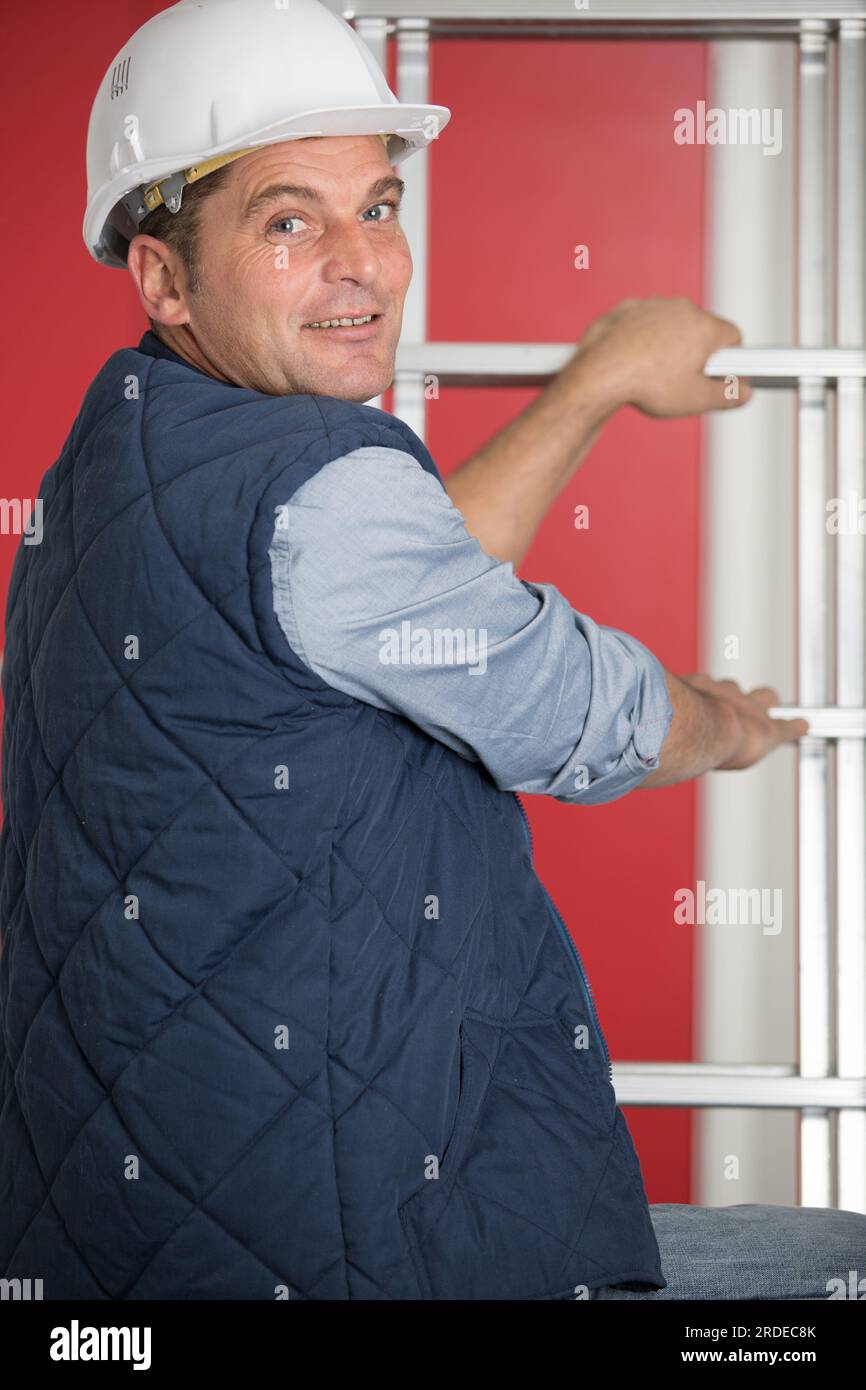 construction worker in helmet climbing a ladder Stock Photo - Alamy