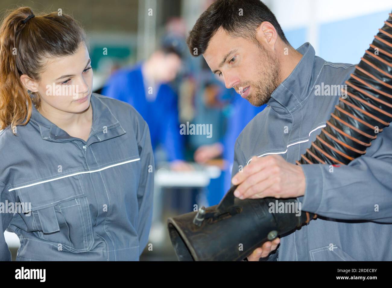 car mechanic talking to female apprentice Stock Photo - Alamy