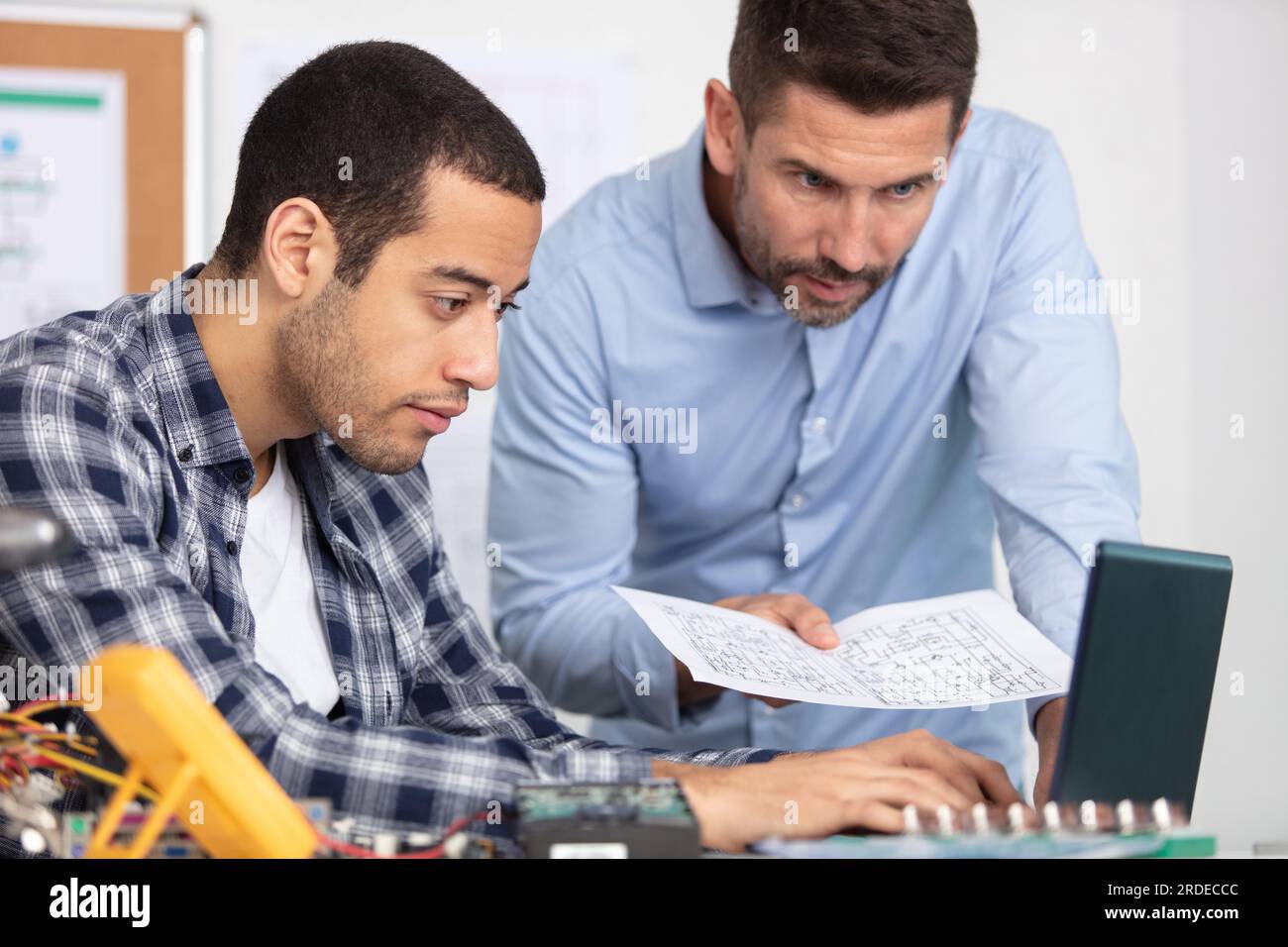 young technician using mutimeter under teachers supervision Stock Photo ...