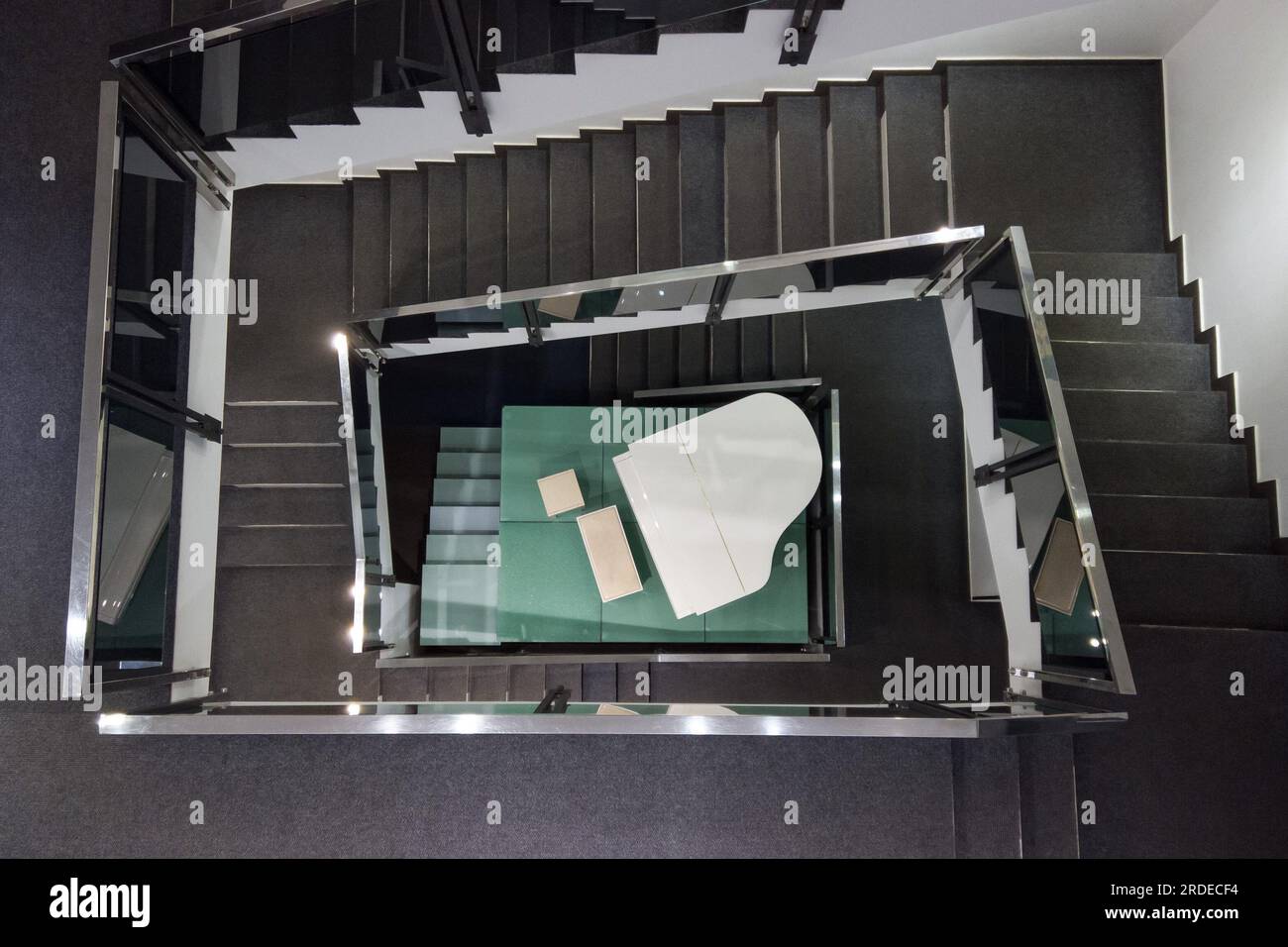 Staircase with white piano. Modern stairs with metal railing in office ...