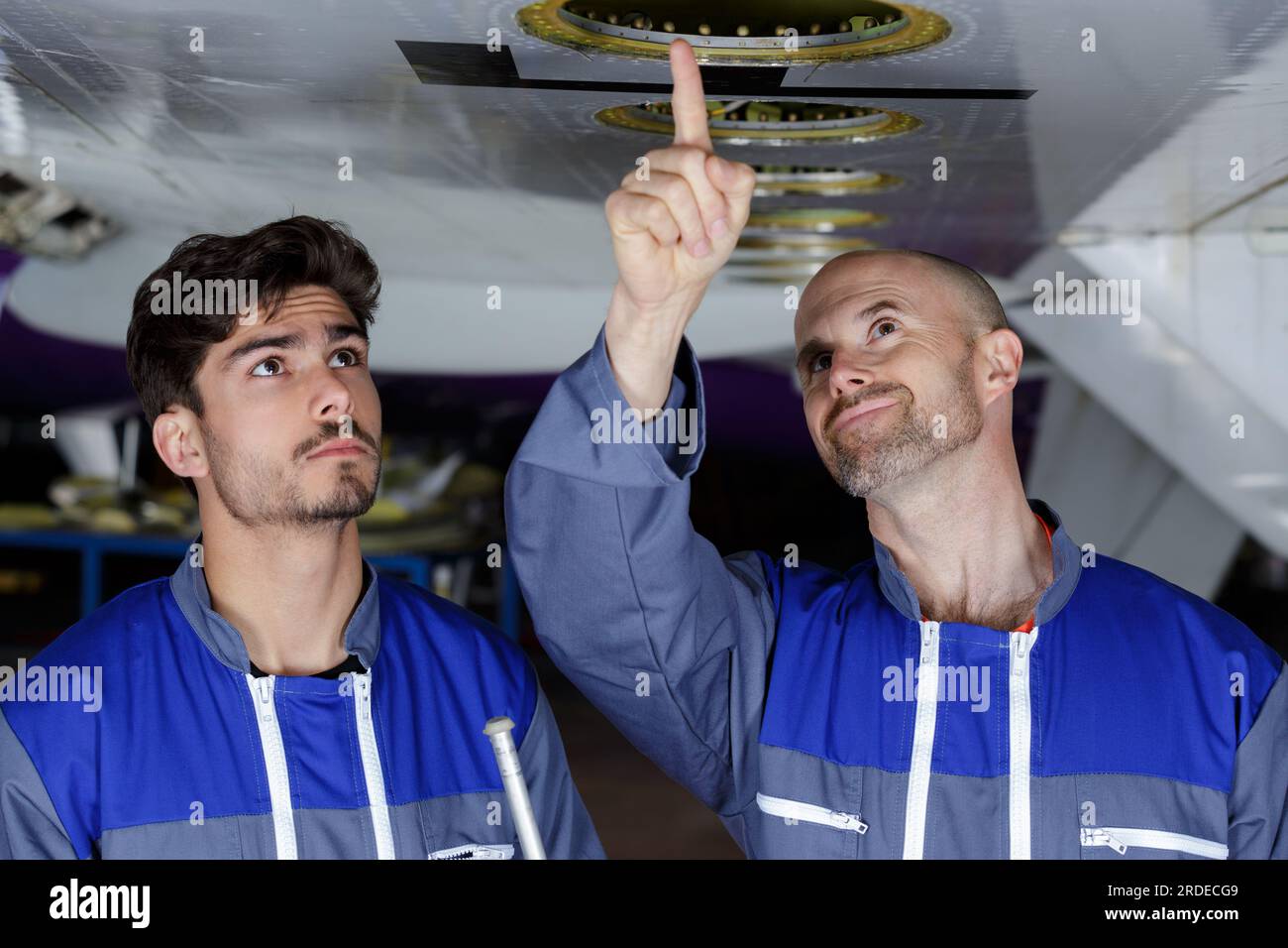 two aircraft mechanics checking something Stock Photo - Alamy