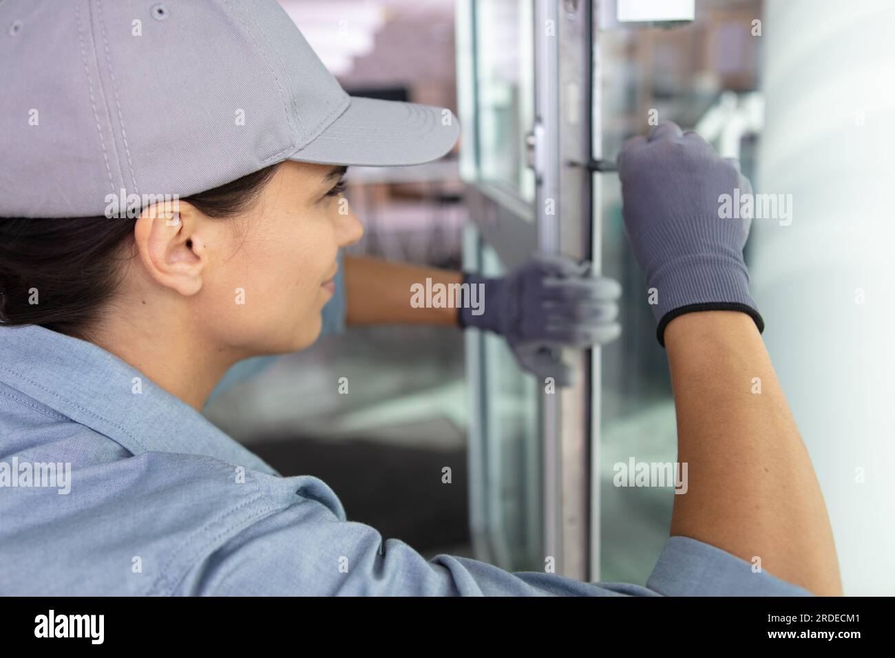 young woman unscrews the fixing screws of the window handle Stock Photo ...